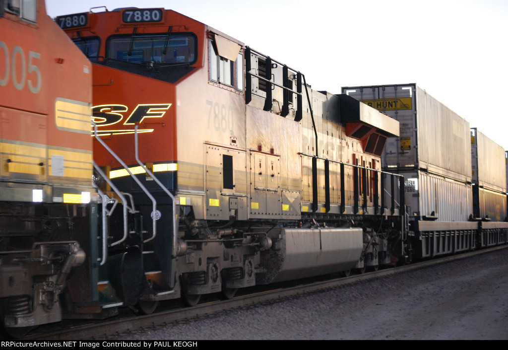 BNSF 7880 rolls eastward into the rising sun as she pushe's a eastbound Z as a rear DPU.
